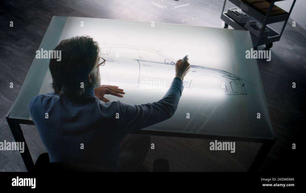 Senior automotive male designer drawing sketch blueprint with marker at ...