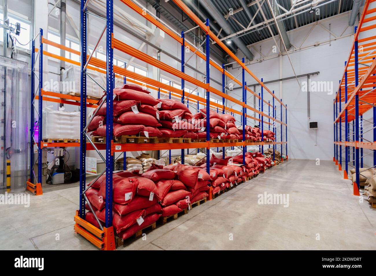 Bags with production on shelves in warehouse. Bags with coffee beans or ...