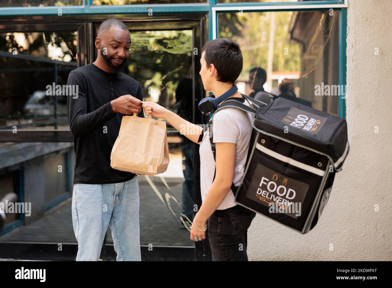 Food delivery service courier delivering lunch to office, woman giving ...