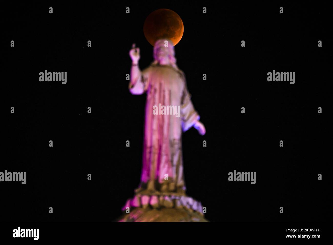 A total lunar eclipse sets behind the Salvador del Mundo monument in ...