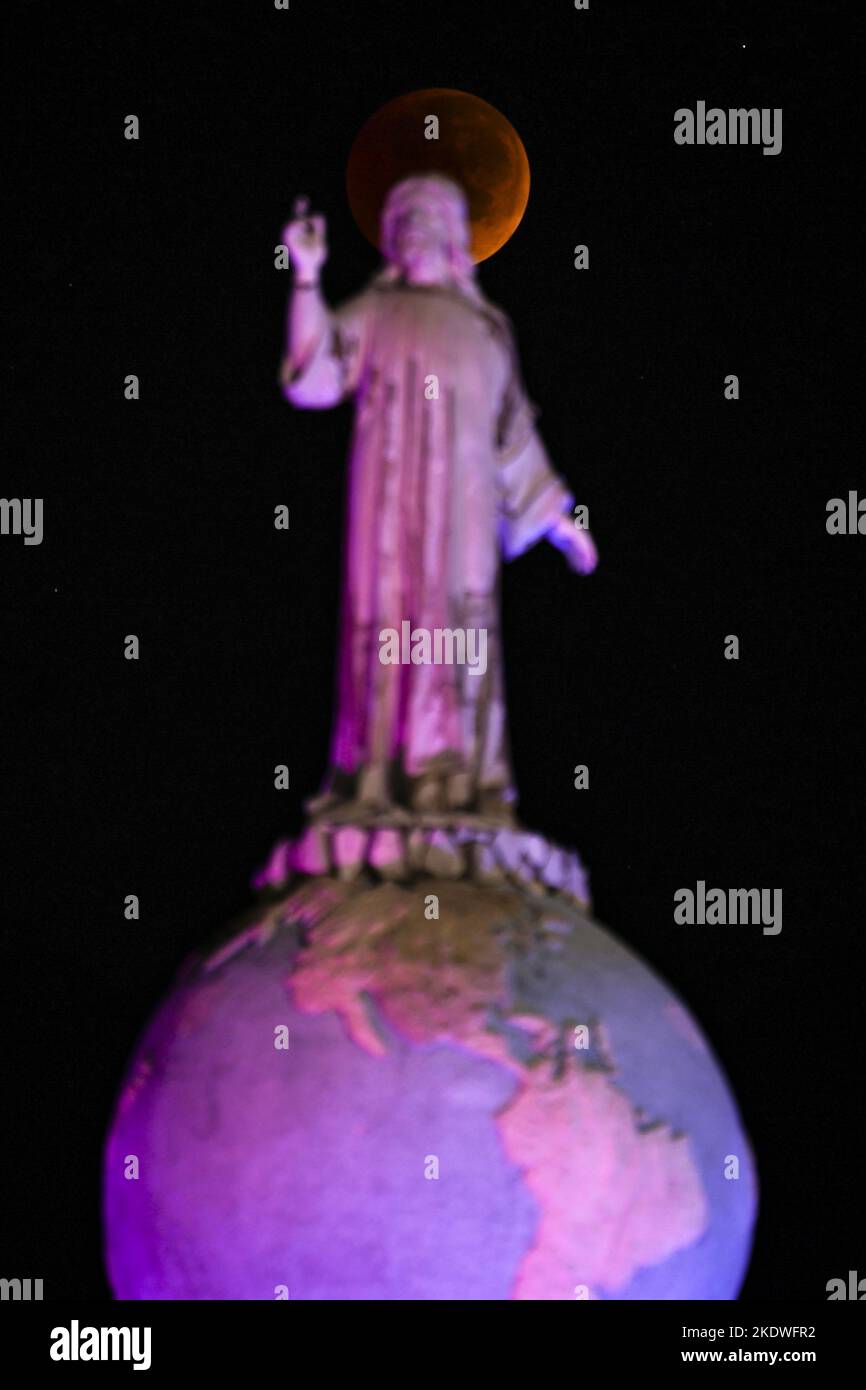 A total lunar eclipse sets behind the Salvador del Mundo monument in ...