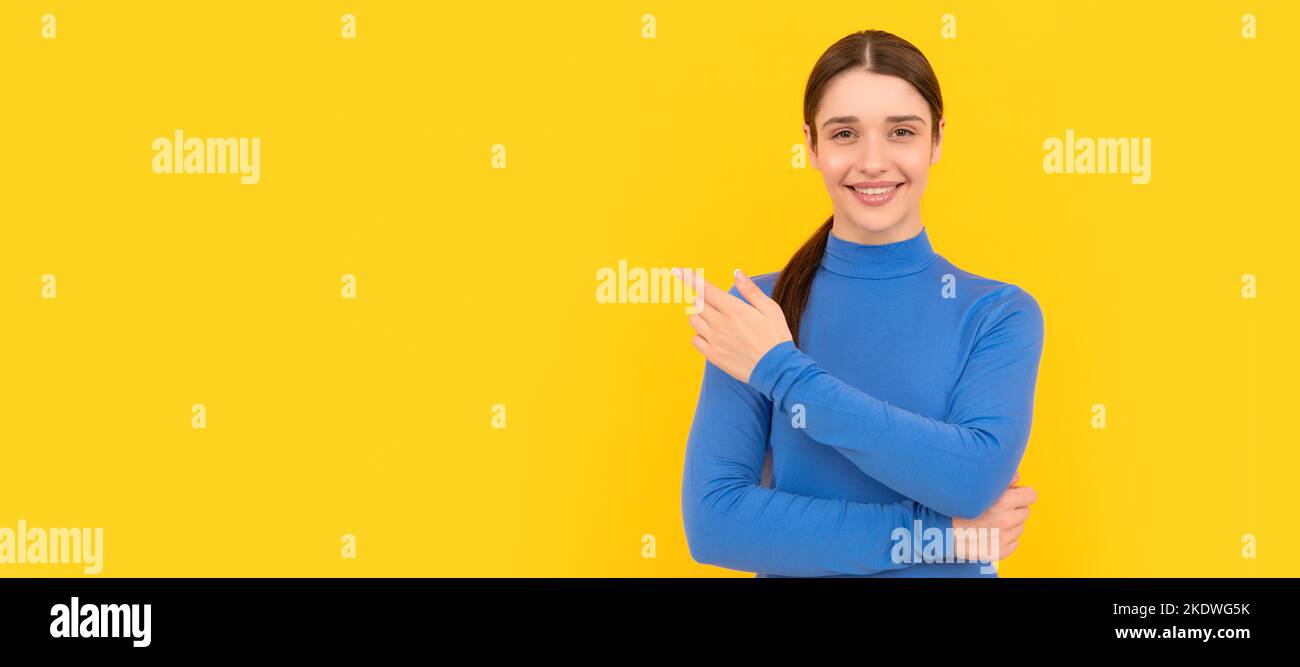 positive woman portrait pointing fingers on copy space yellow ...