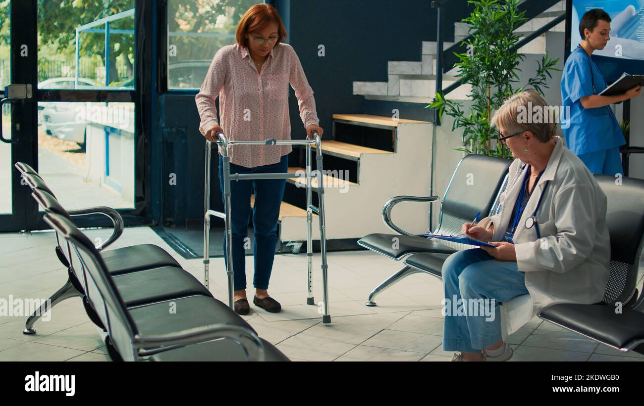 Asian patient with leg injury walking with walk frame and doing ...