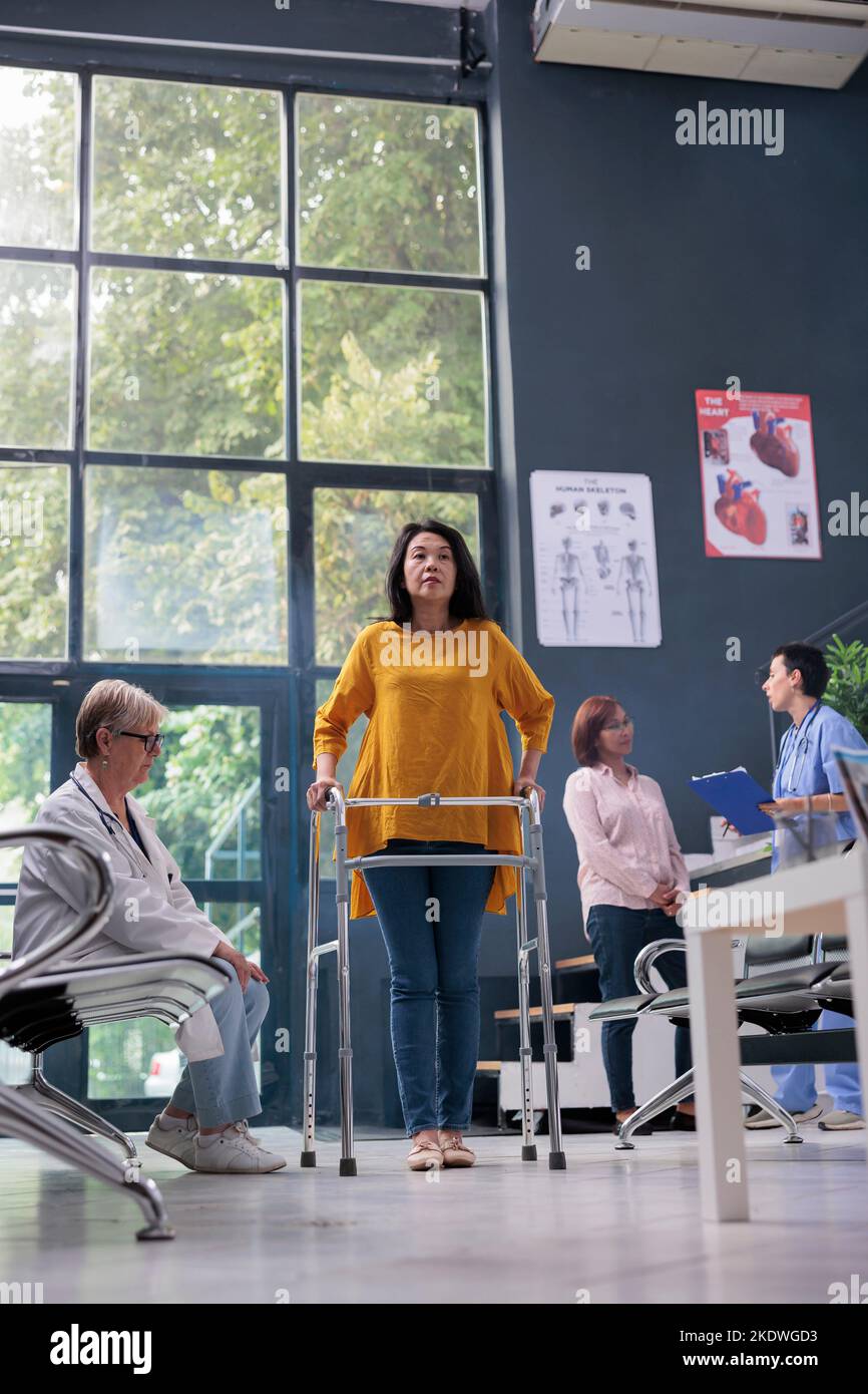 Senior physician attending physiotherapy with injured patient, doing rehabilitation examination ...