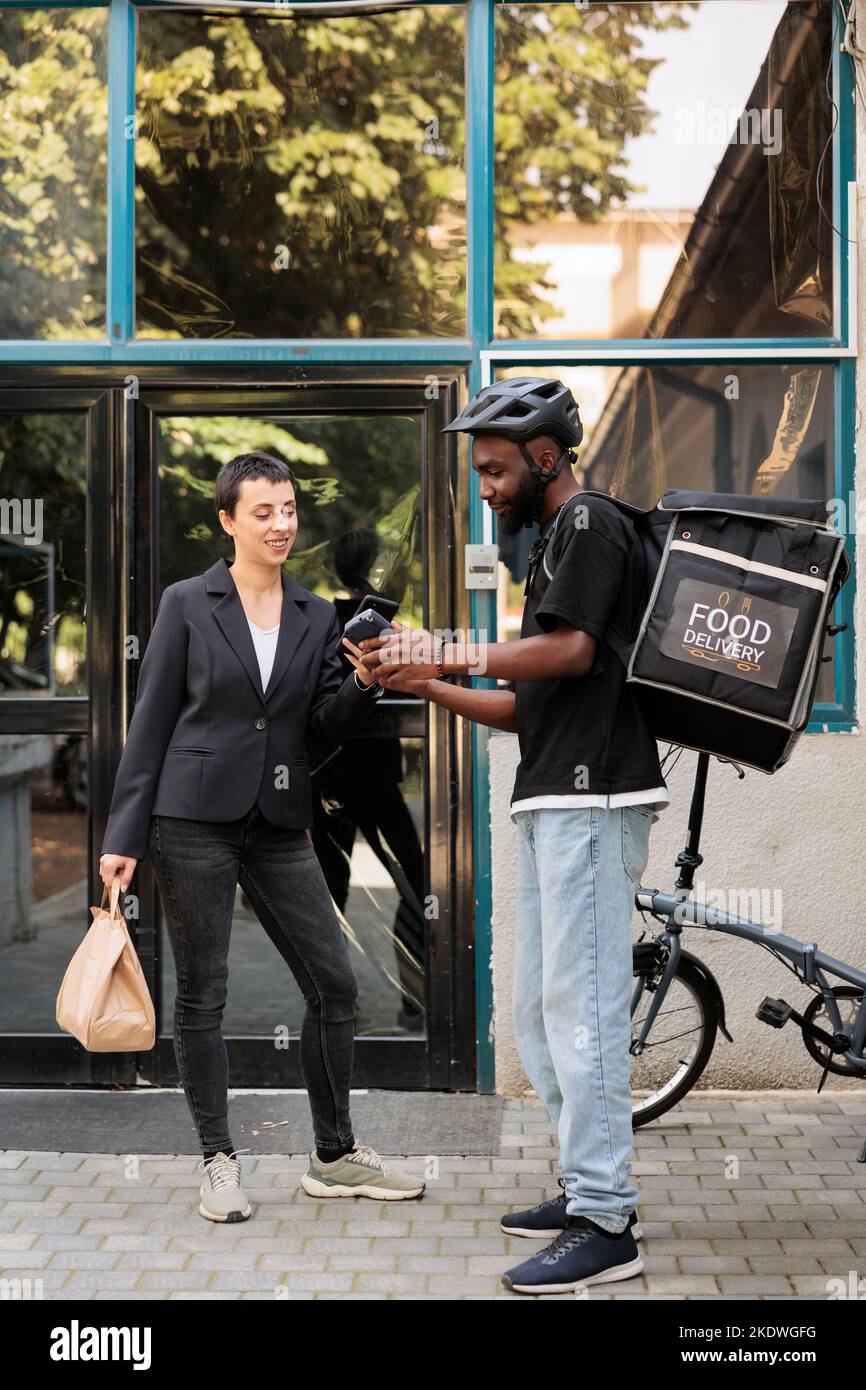 Workplace food delivery, smartphone pos terminal payment, smiling woman ...