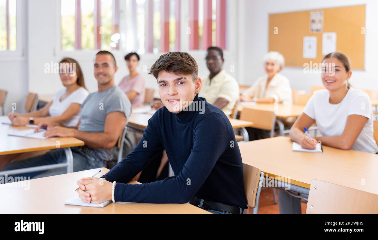Positive young man attending lecture in college Stock Photo - Alamy