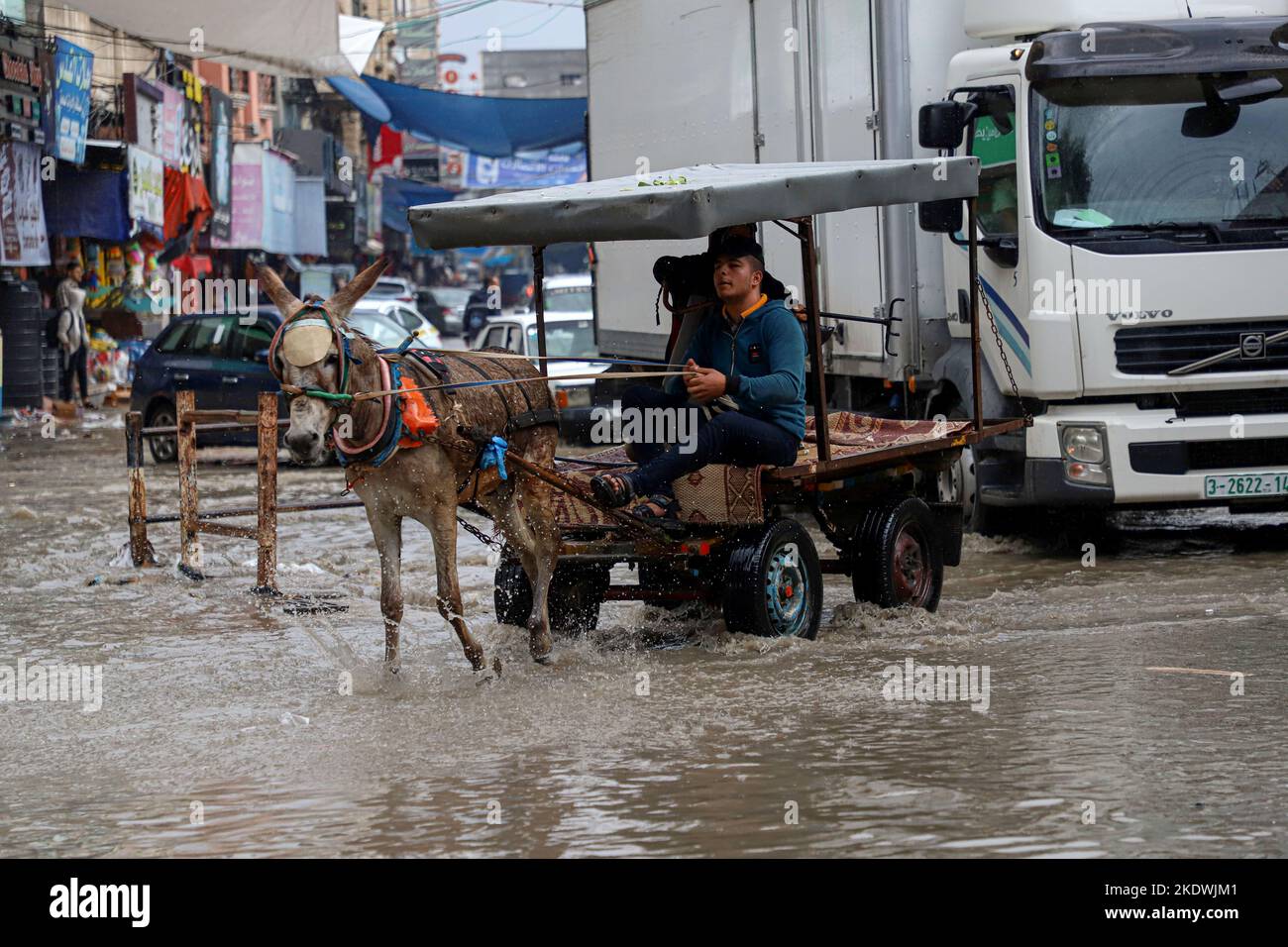 Gaza. 8th Nov, 2022. A man rides a donkey cart to cross a flooded ...