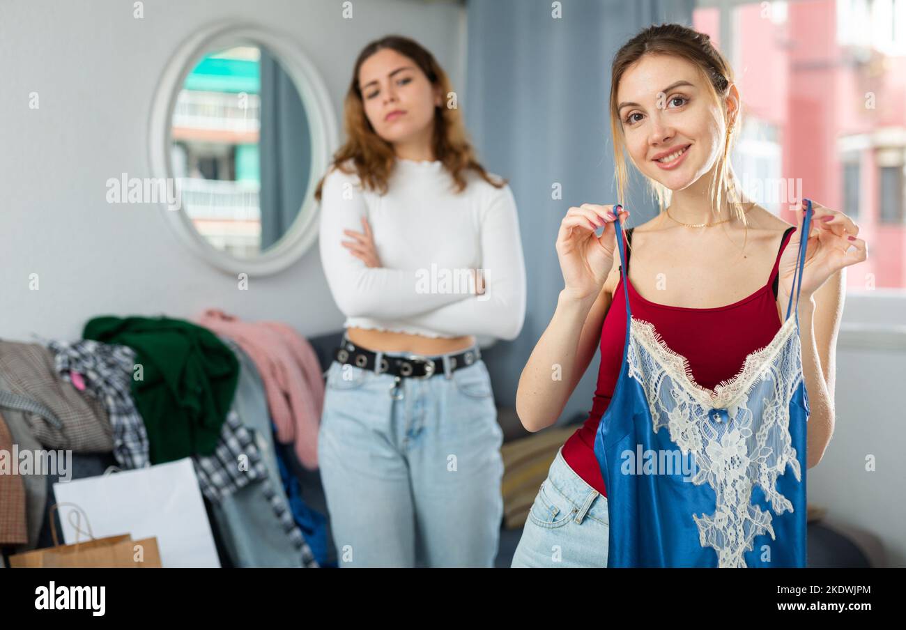 Two young women choosing clothes to wear Stock Photo - Alamy