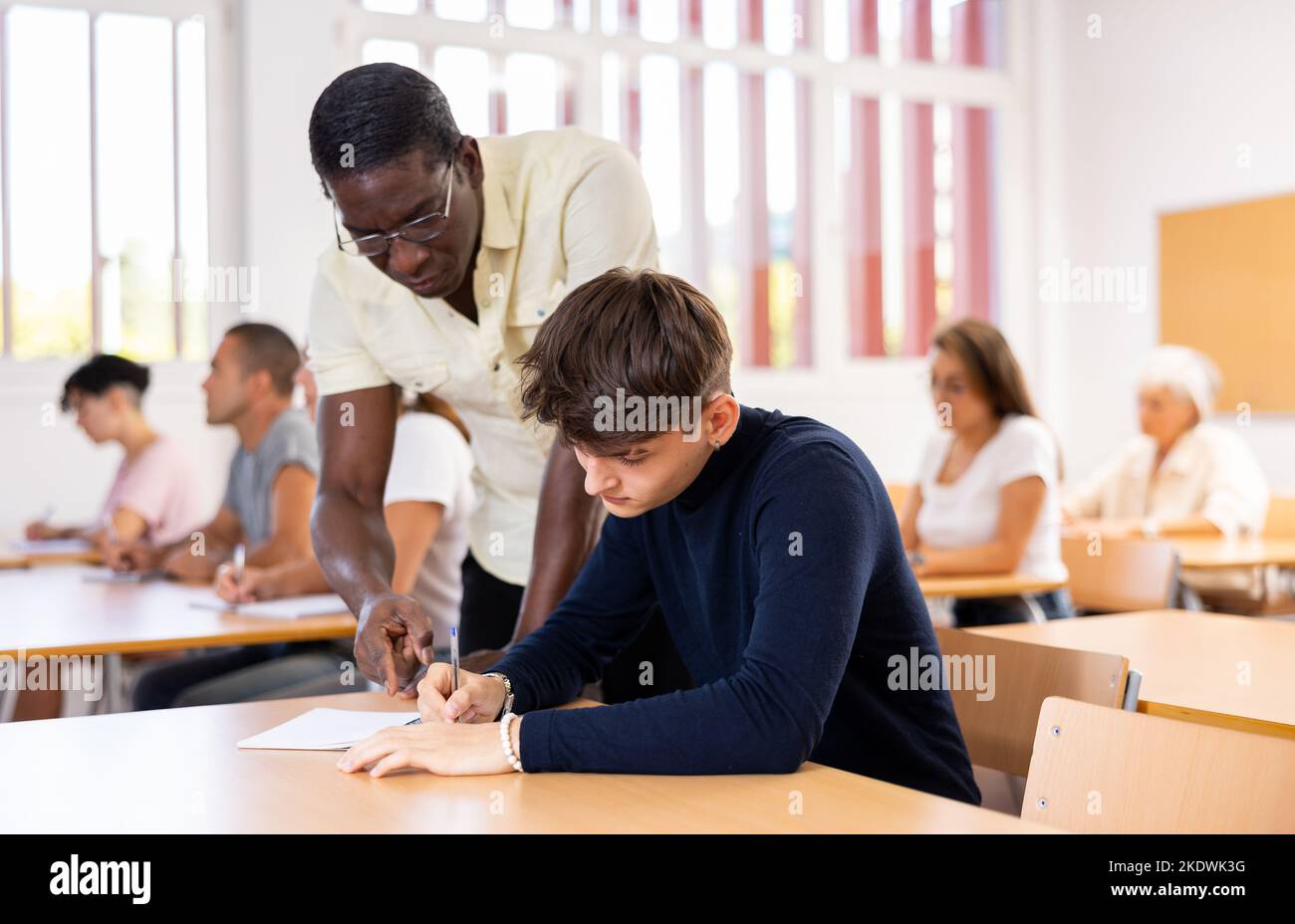 Young man listening to teacher during classes in university Stock Photo ...