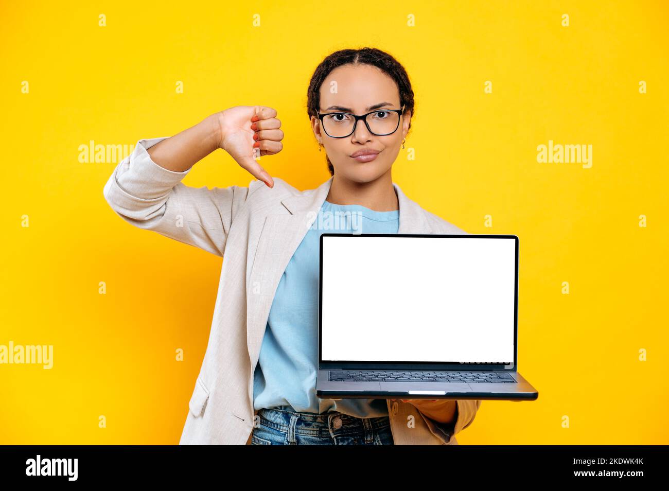 Confused young brunette mixed race woman, hold laptop computer with ...