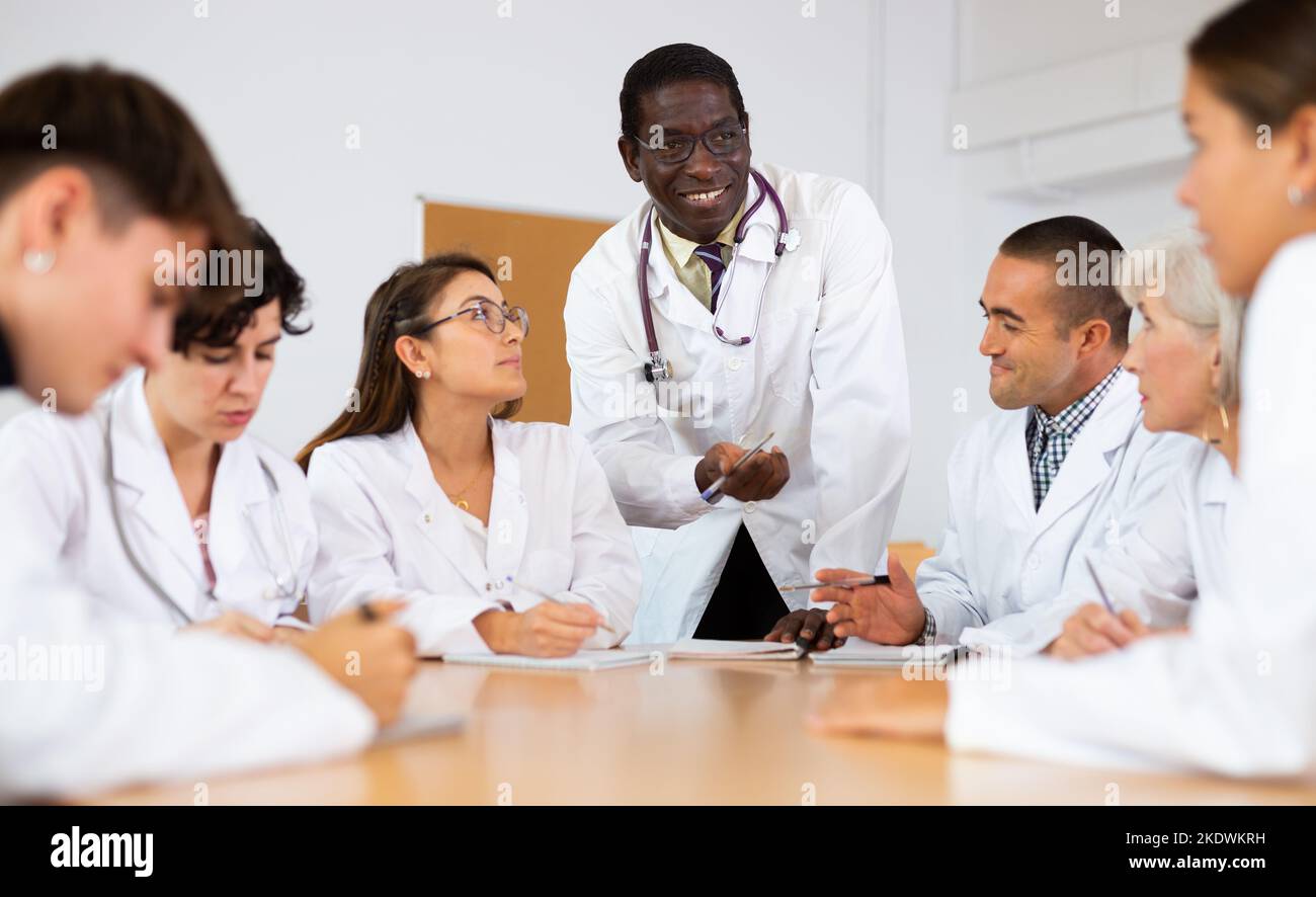Medical workers listening to african american lecturer during ...