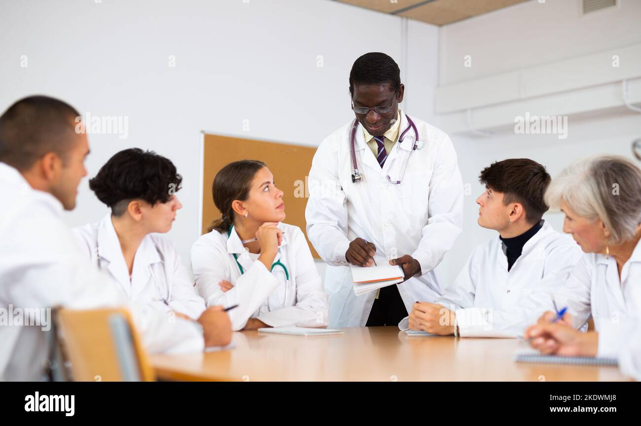 African american male doctor together with colleagues conducts a round ...