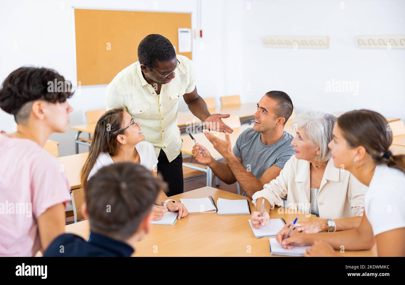 People of different ages communicating in speaking club with African ...