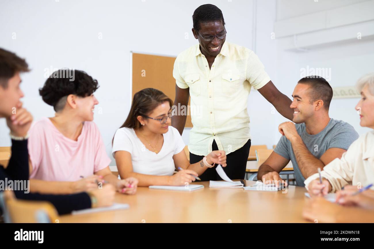 People of different ages communicating in speaking club with African ...