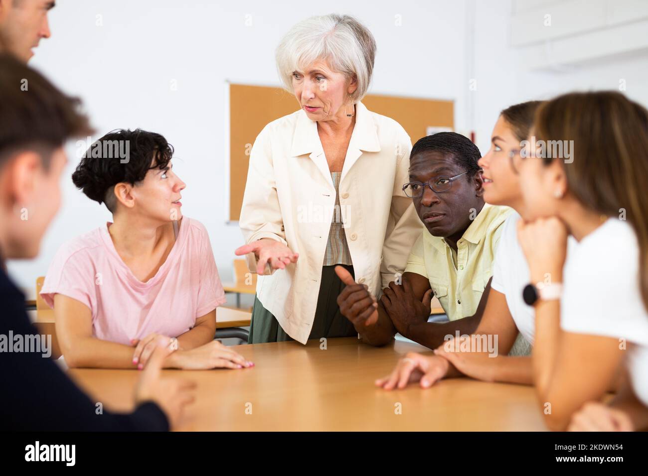 Senior woman participating in English language speaking club with ...