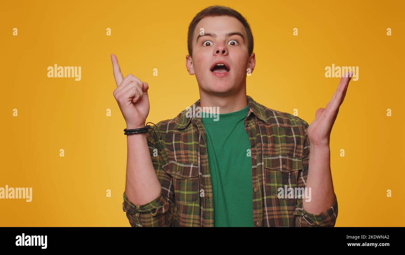 Eureka. Inspired man 20s in shirt pointing finger up with open mouth ...
