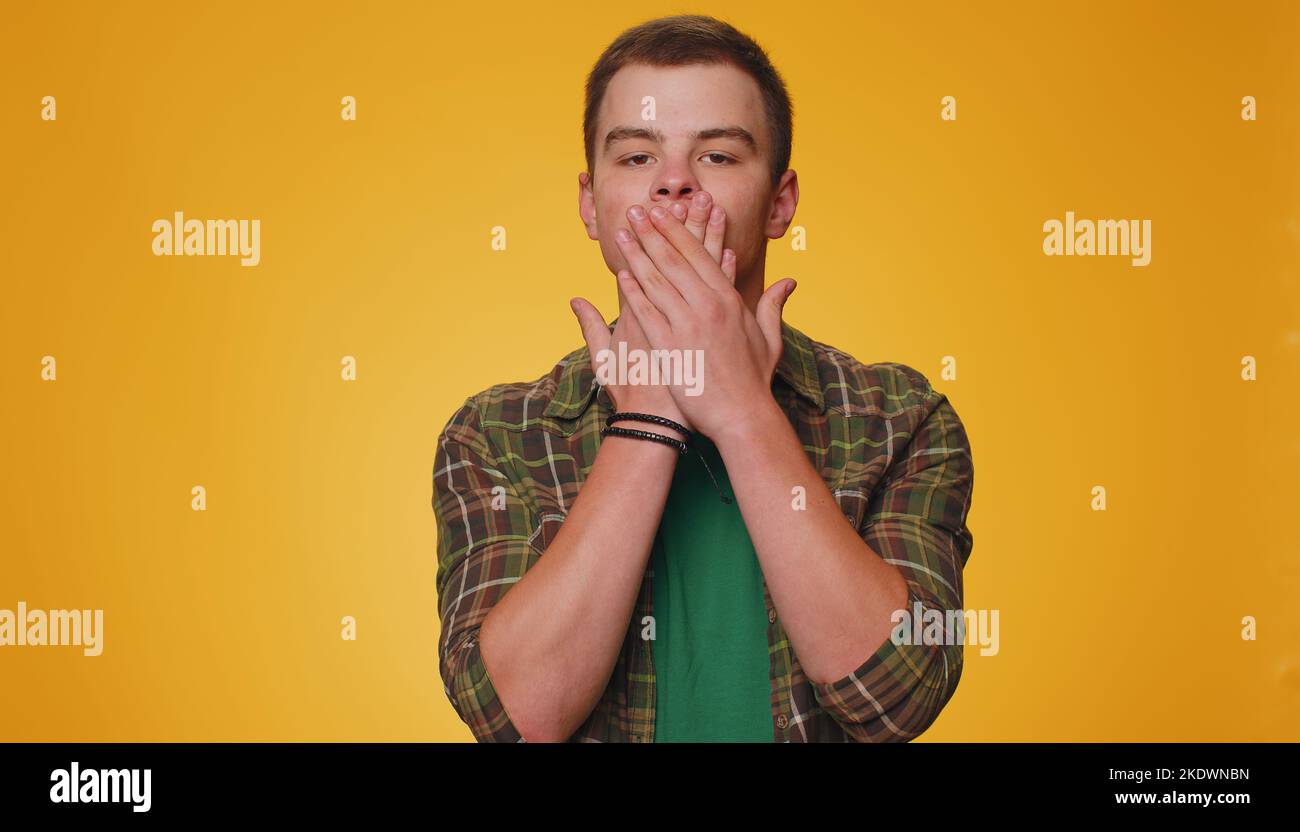 I will not say anyone. Frightened sincere man closing his mouth with ...