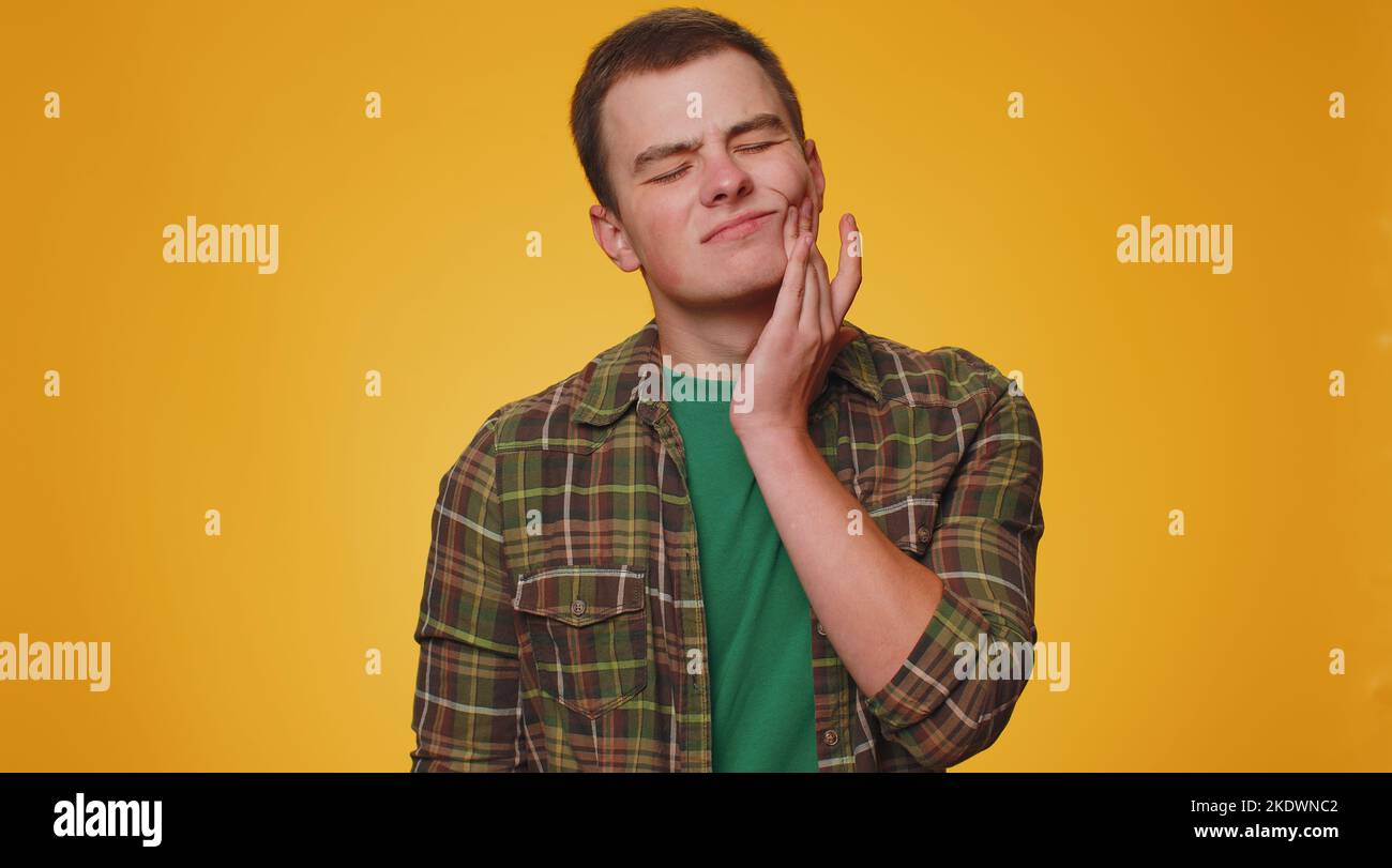 Teenager young man touching sore cheek suffering from toothache ...