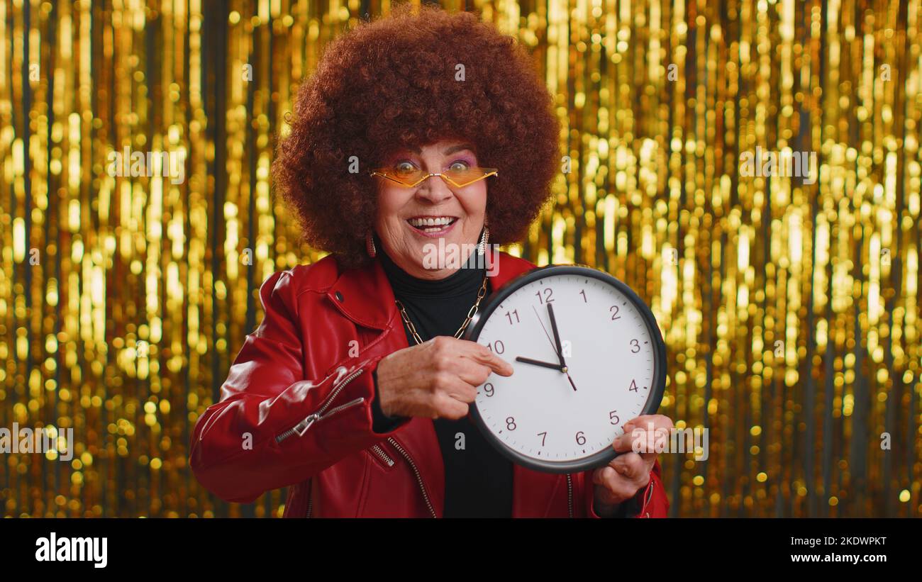 It is your time. Portrait of stylish senior woman showing time on clock ...