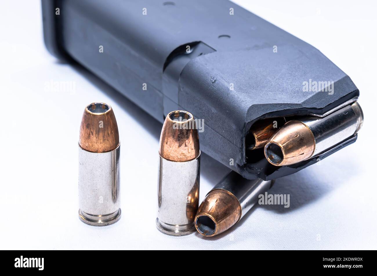 A loaded 9mm pistol magazine with three more hollow point bullets next ...