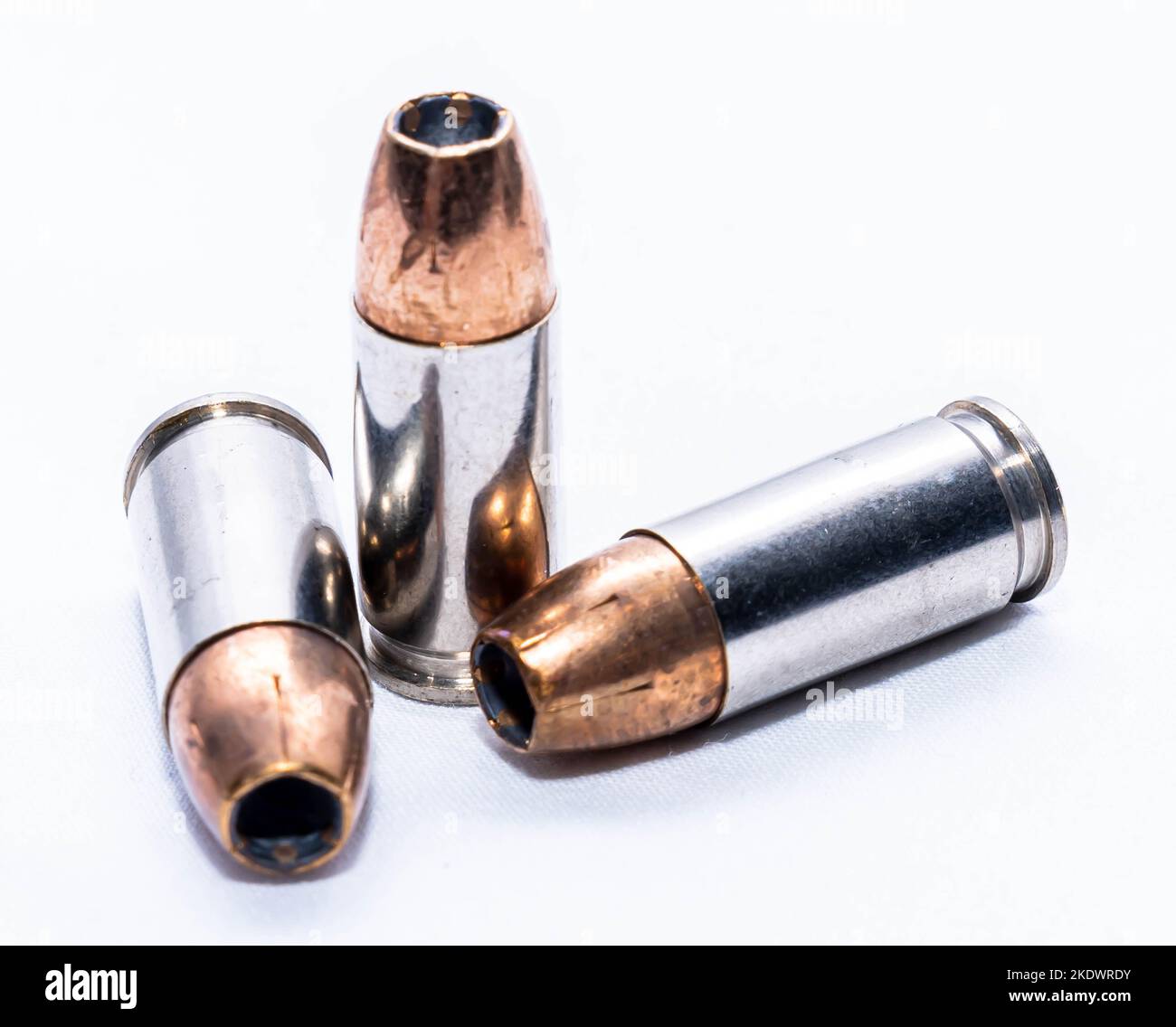 Three 9mm hollow point bullets grouped together on a white background ...