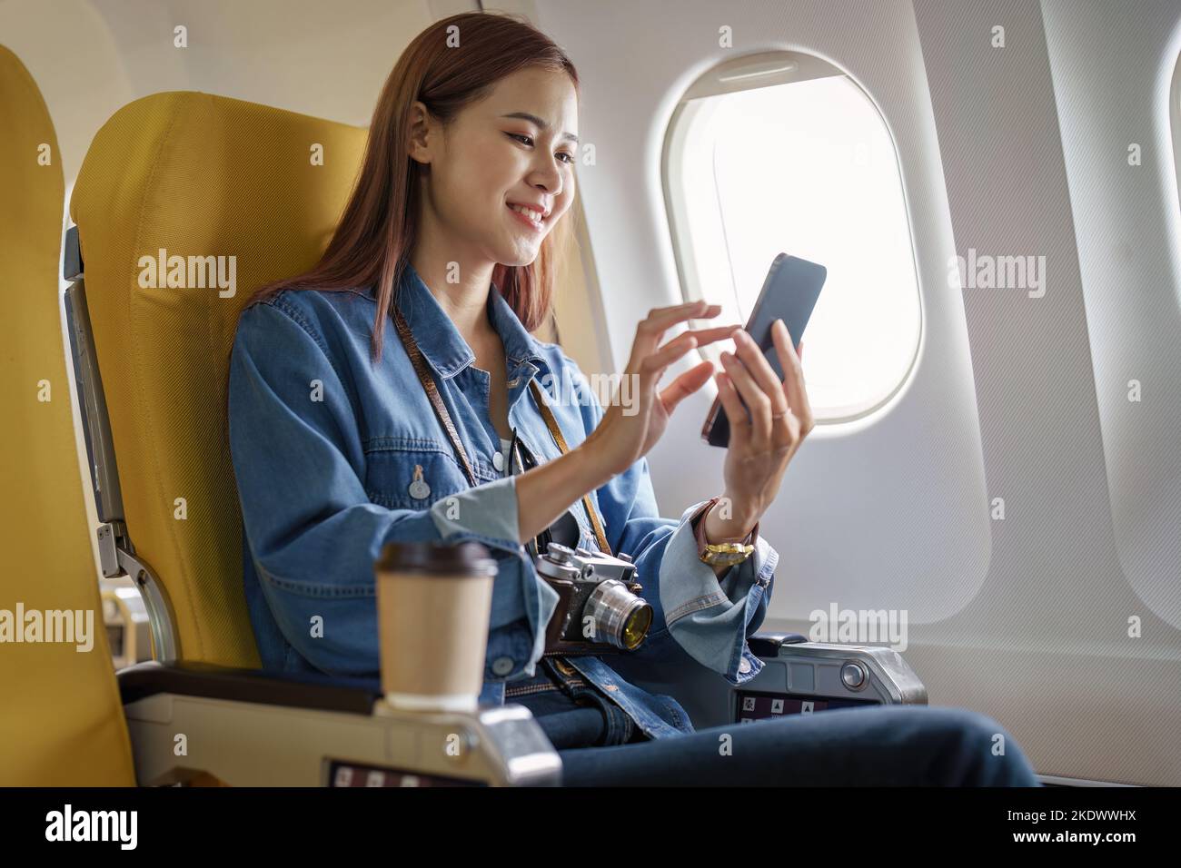 Attractive portrait of Asian woman sitting at window seat in economy ...