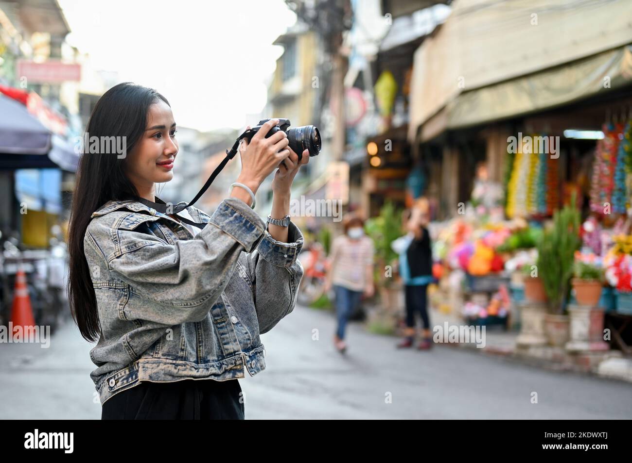 Beautiful young Asian woman taking a photo of Asian local market while ...