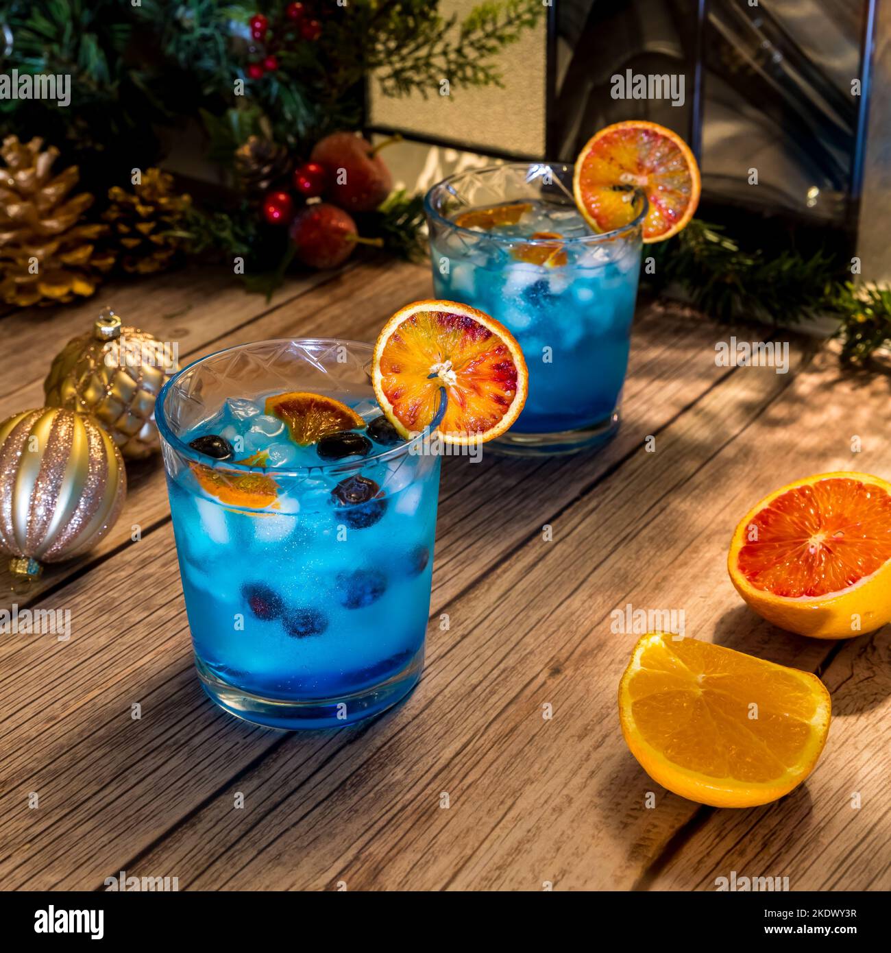 Vivid ocean breeze blue cocktails garnished with blueberries and orange ...