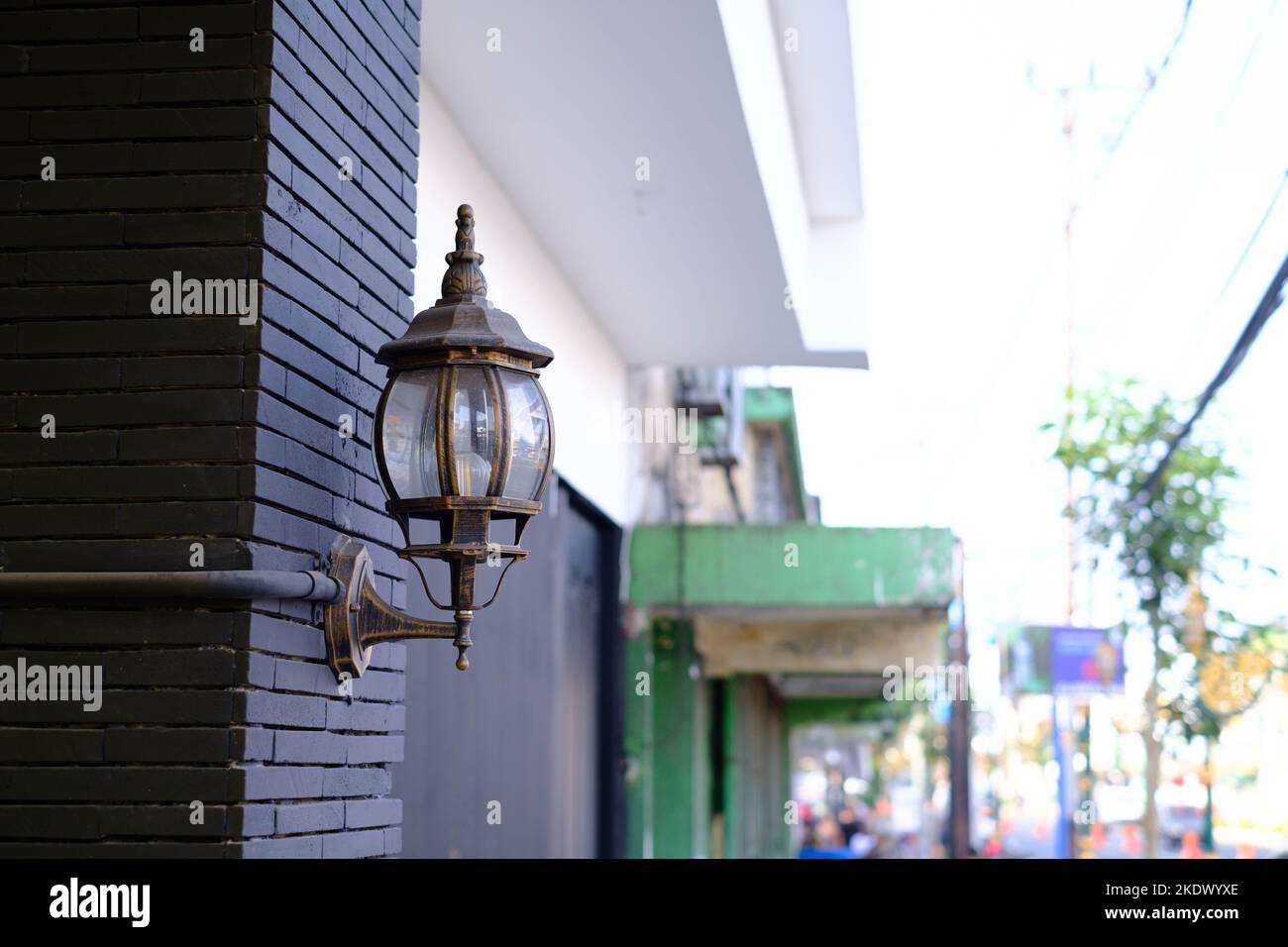 Vintage street lamp mounted on a brick wall that has been painted black ...