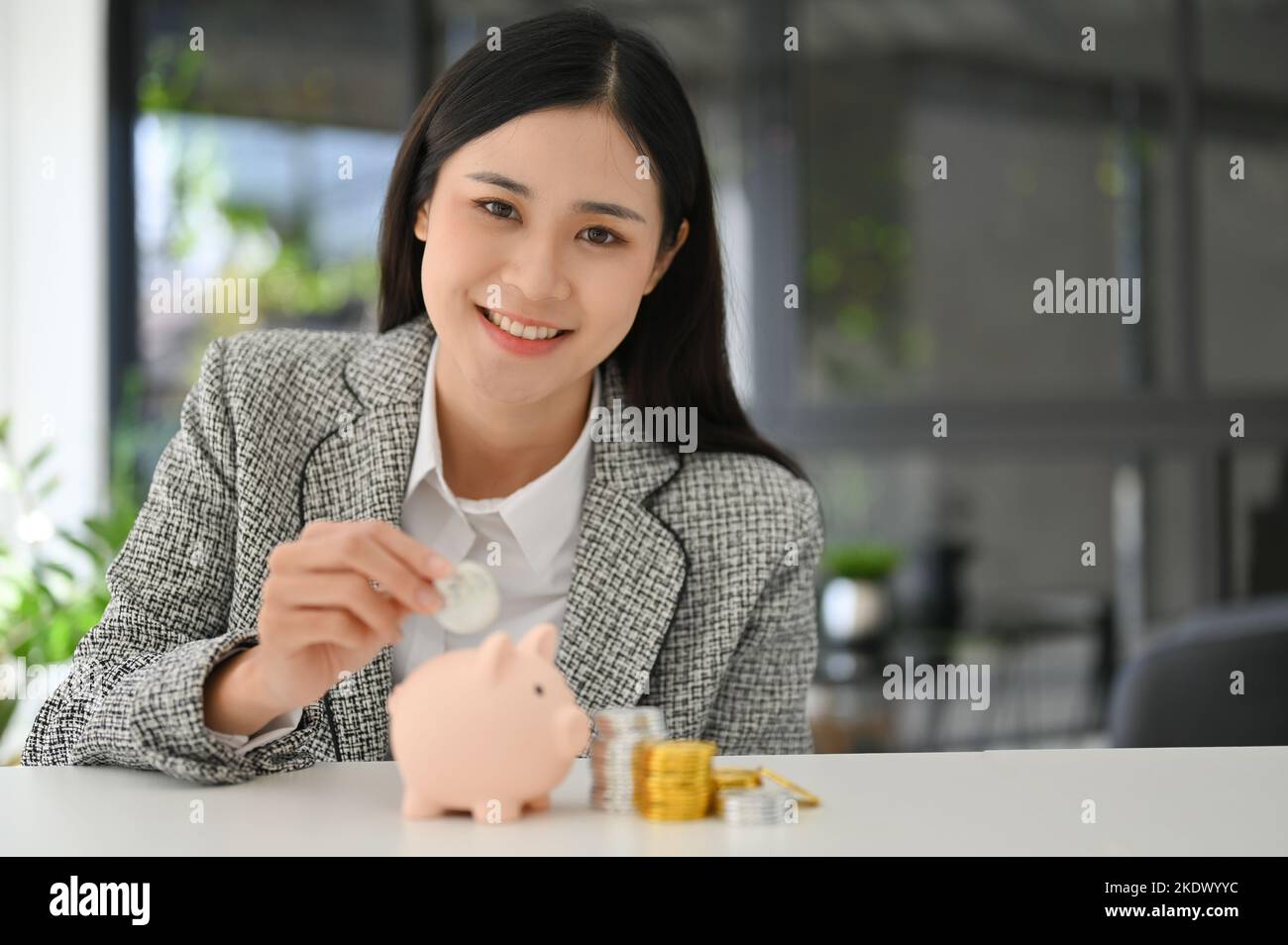 Attractive and charming young Asian businesswoman insert coins in a pin ...