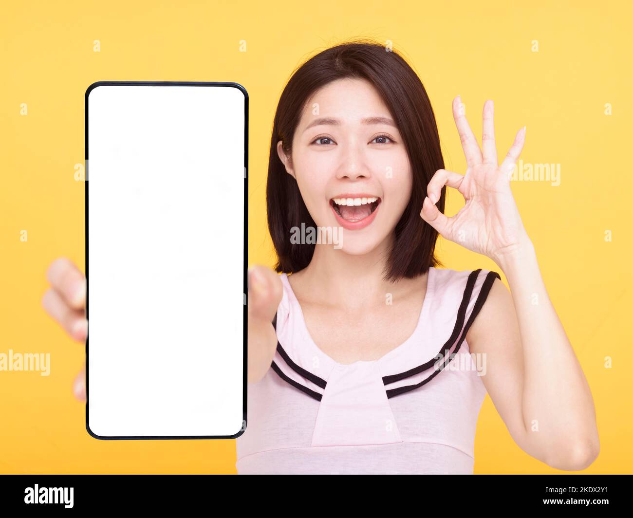 Happy Young woman showing blank screen Smart phone and ok gesture Stock ...