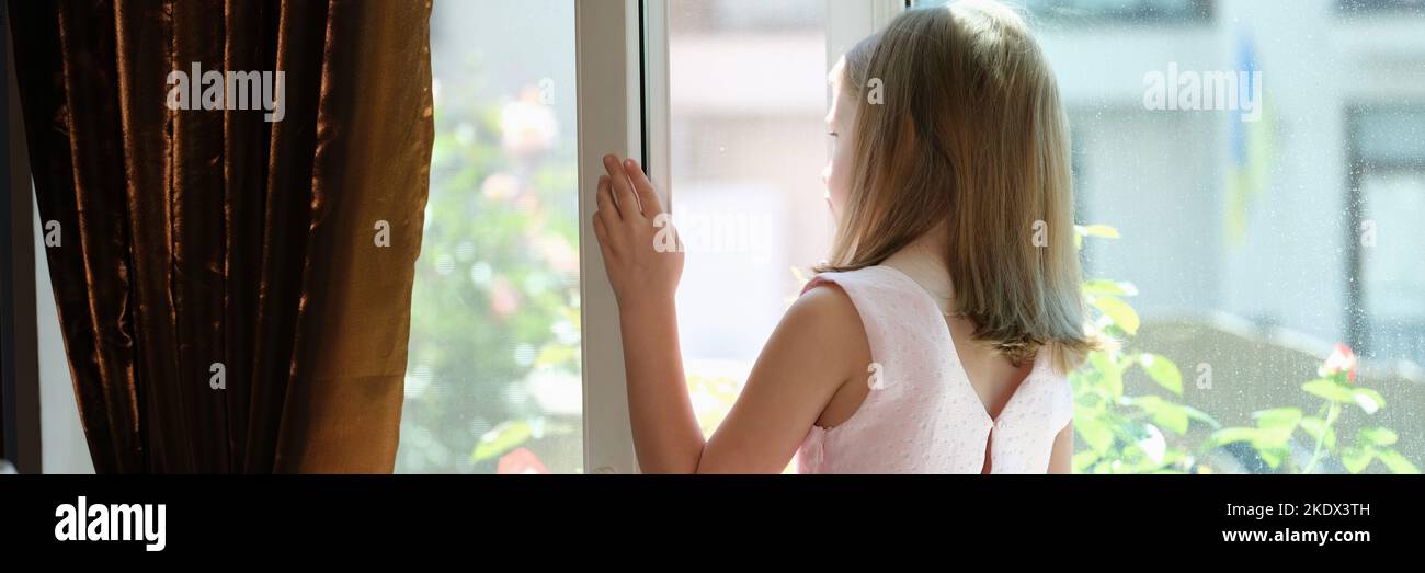 Little girl standing at open window at home back view Stock Photo - Alamy