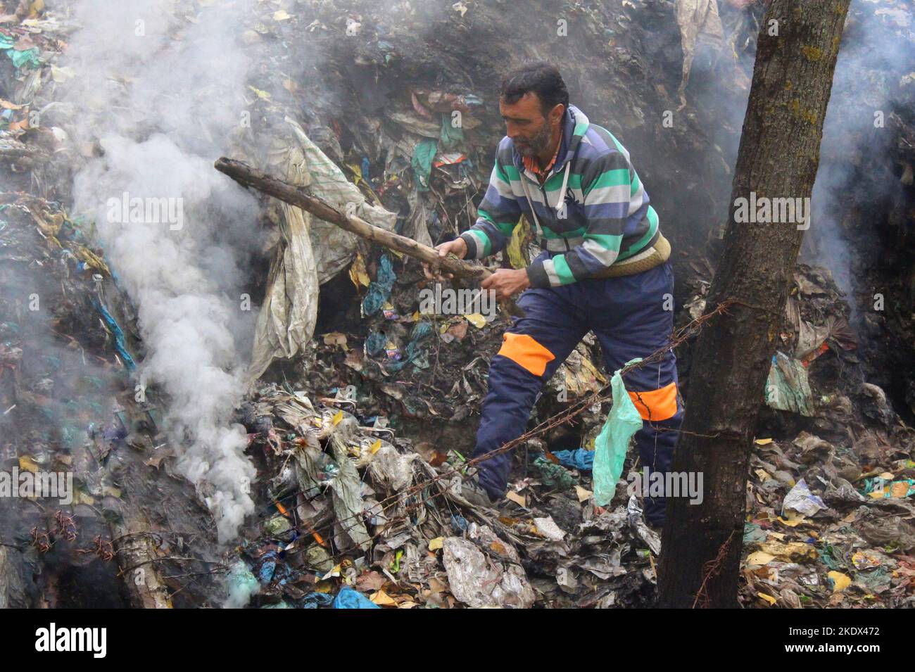 A man burning garbage at illegal dumping site in north Kashmirs Sopore ...