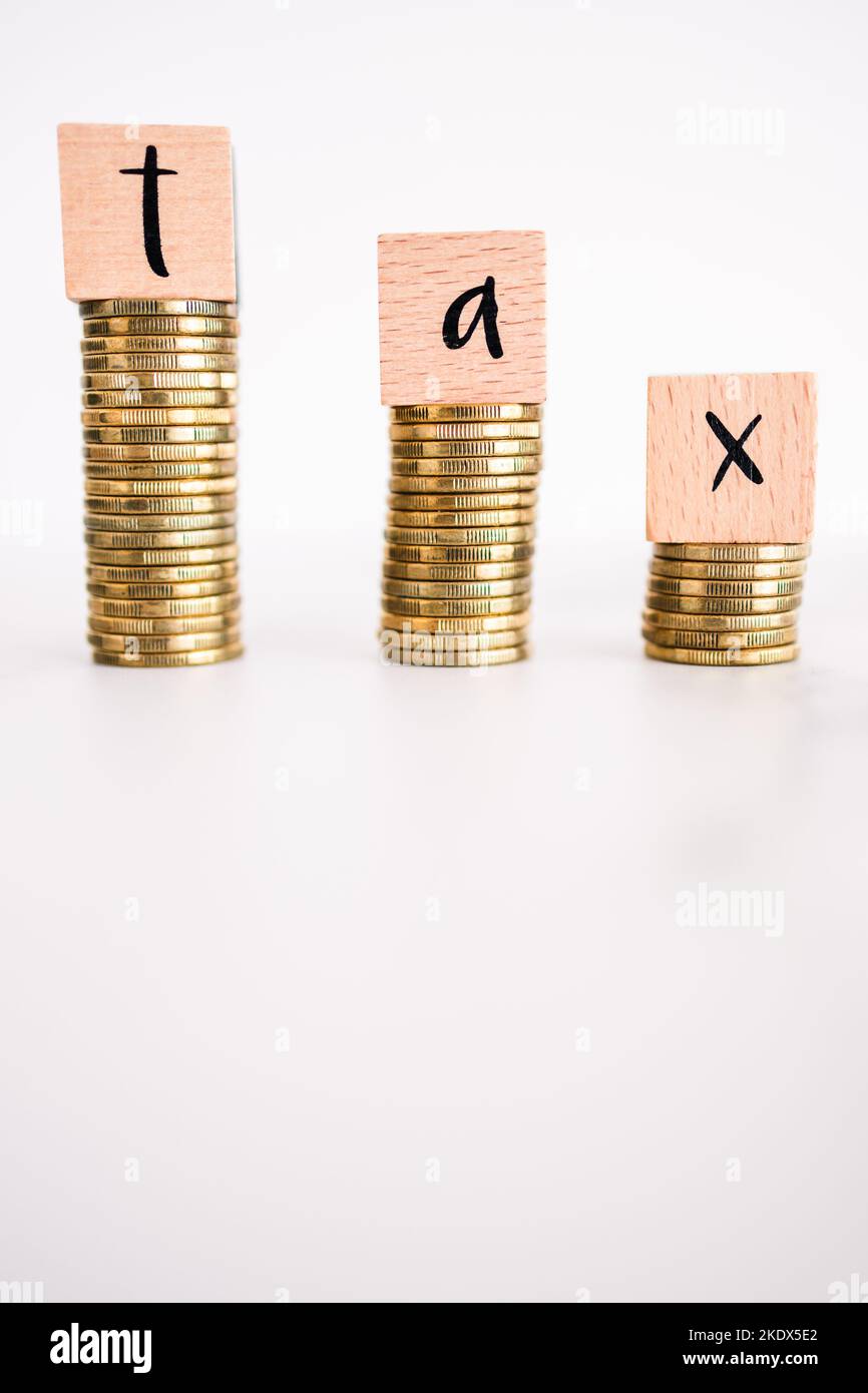 Tax text on top of decreasing stacks of coins, symbol of decreasing tax ...