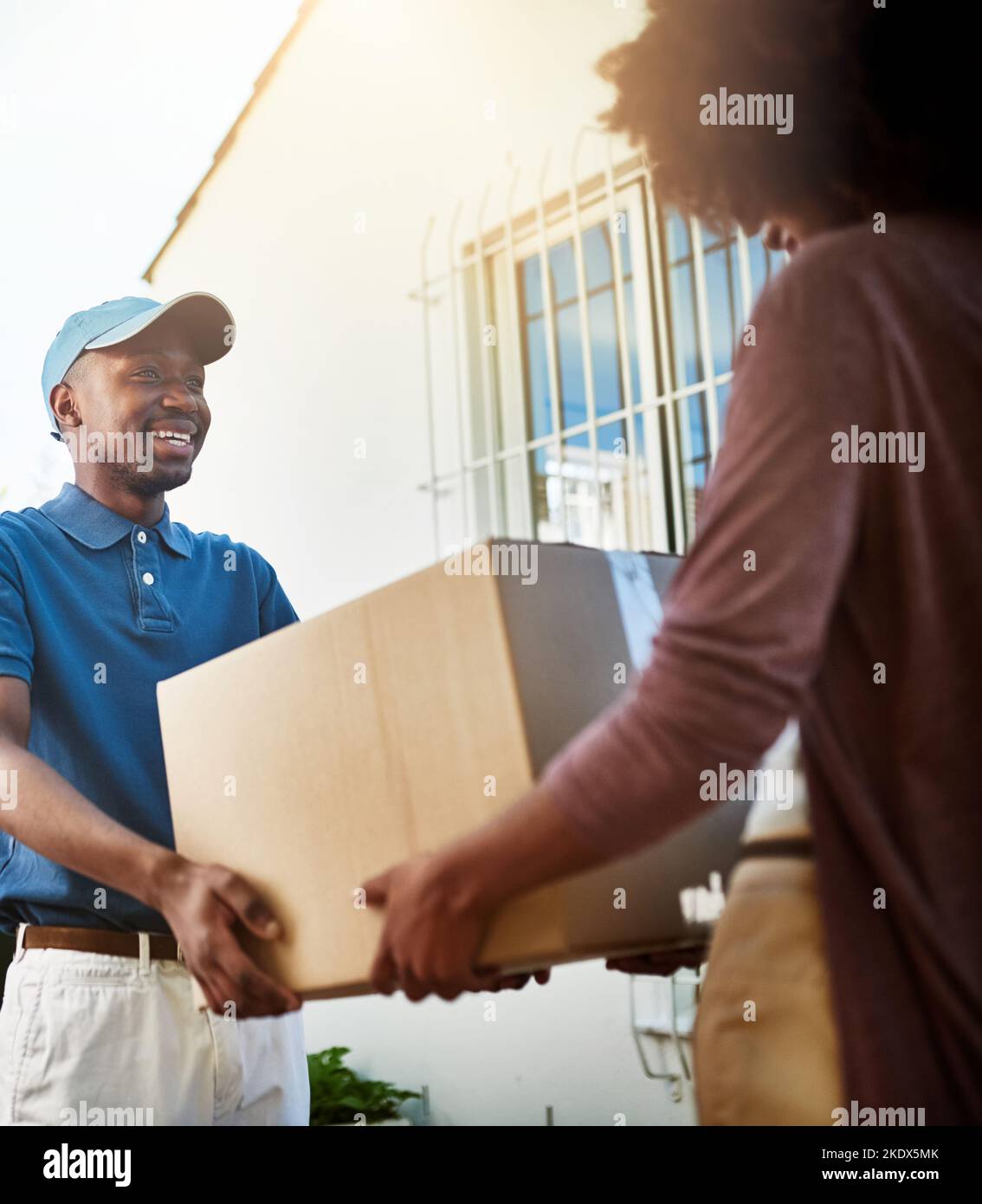Putting your package in your hands. a young postal worker delivering a ...