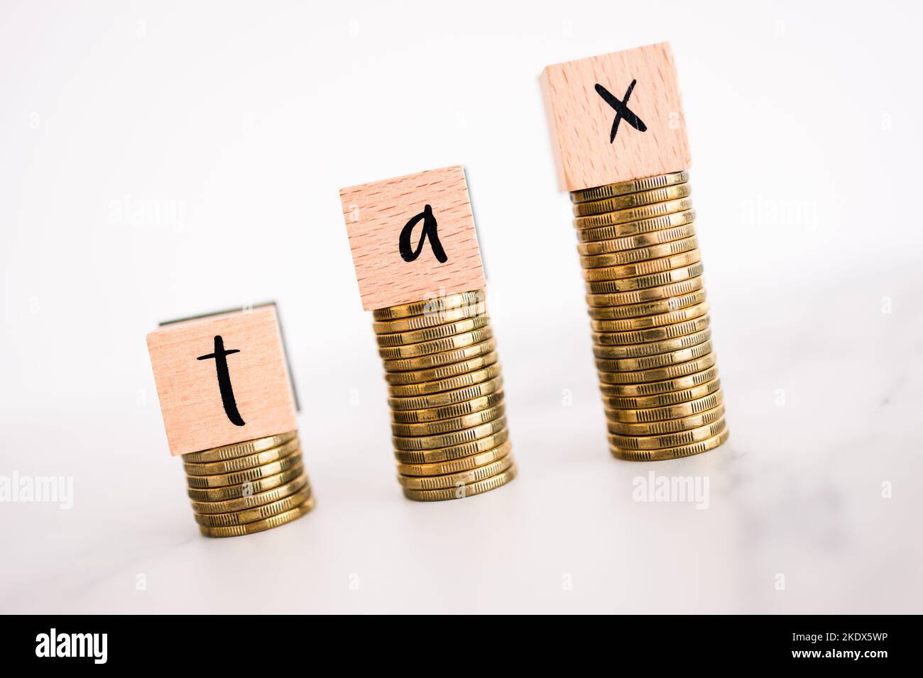 Tax text on top of growing stacks of coins, symbol of increasing tax ...