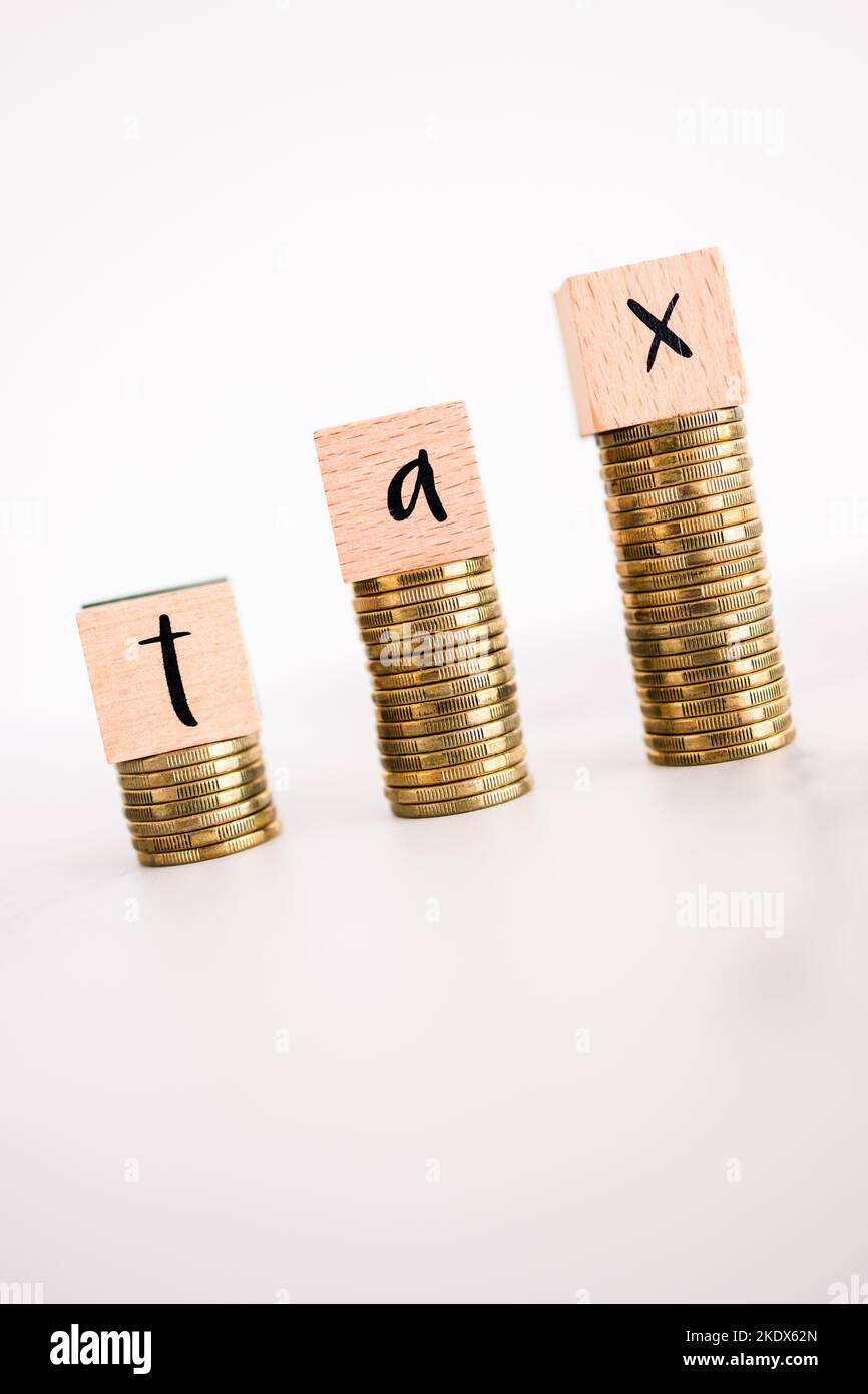 Tax text on top of growing stacks of coins, symbol of increasing tax ...