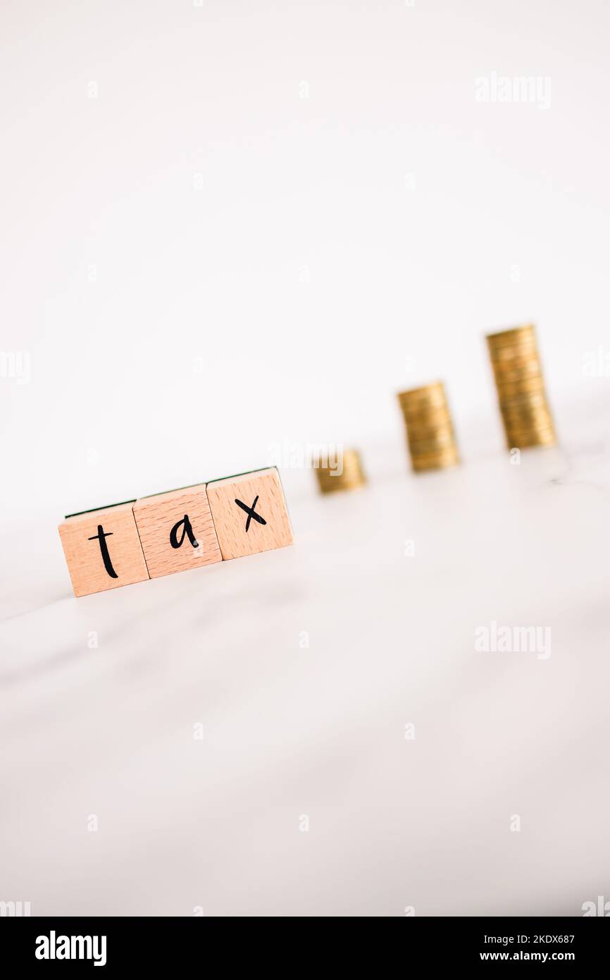 Tax text on top of growing stacks of coins, symbol of increasing tax ...