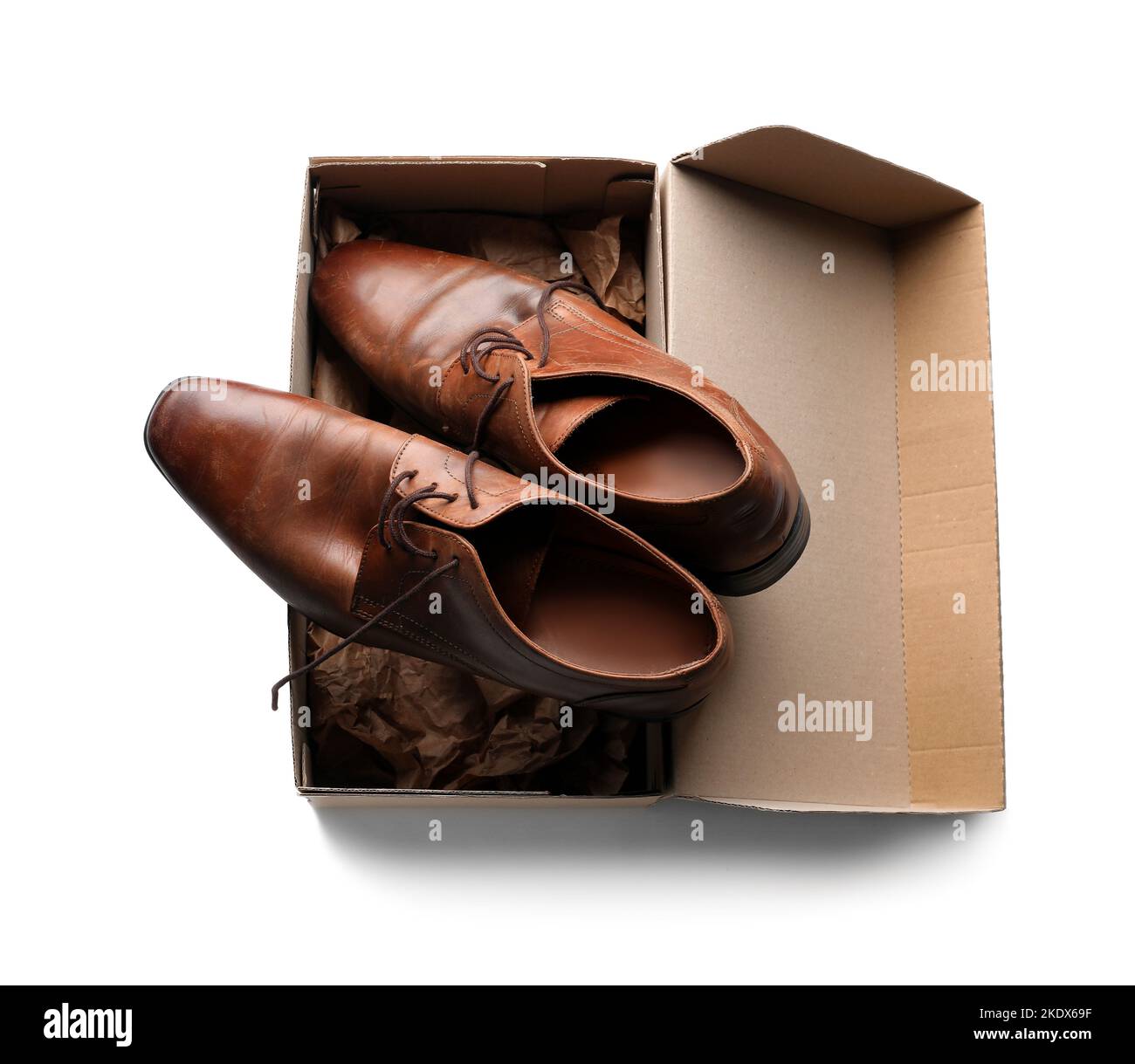 Cardboard box with brown shoes on white background Stock Photo - Alamy