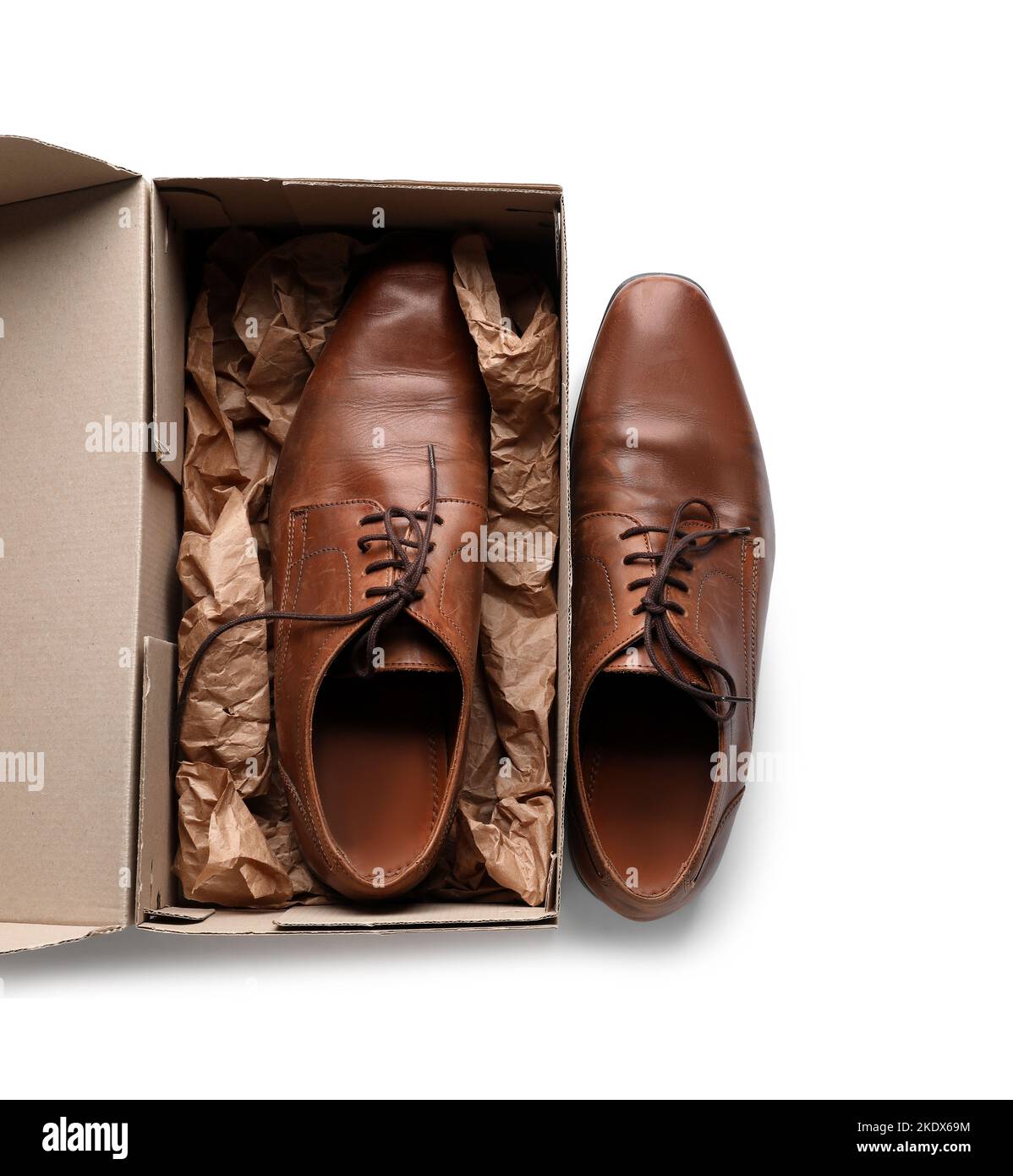 Cardboard box with brown shoes on white background Stock Photo - Alamy