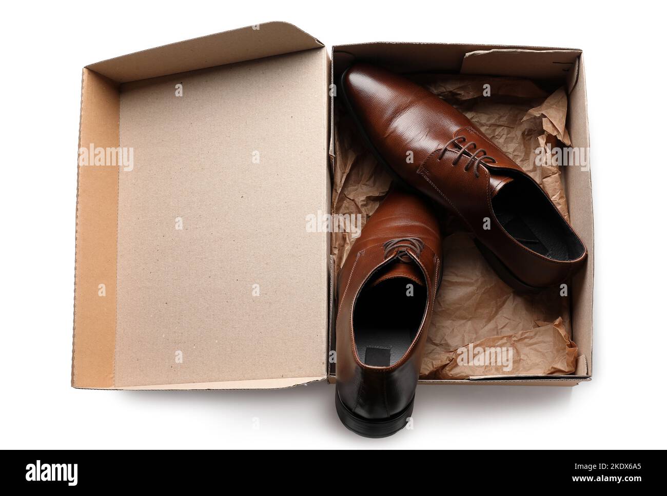 Cardboard box with brown shoes on white background Stock Photo - Alamy
