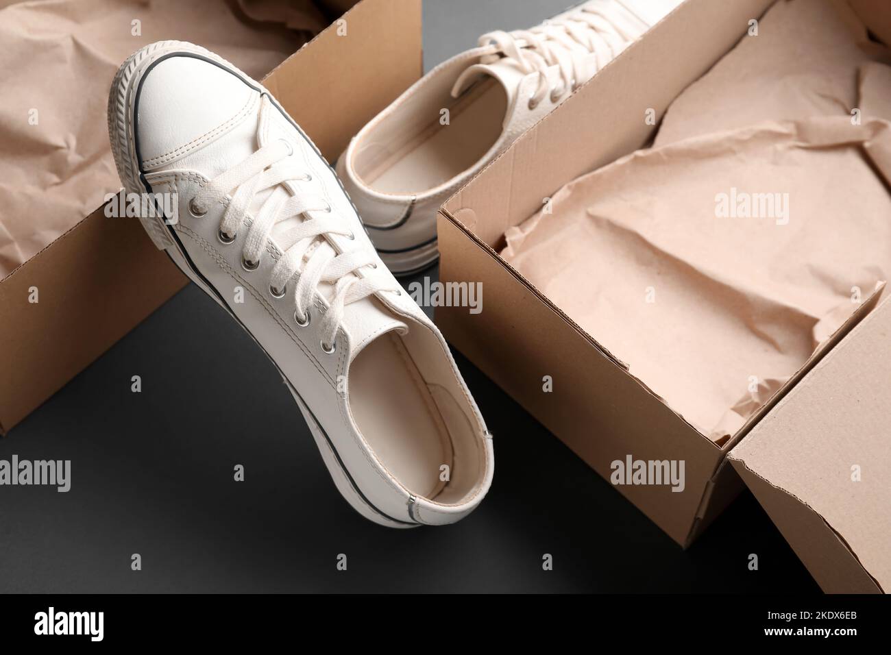 Cardboard boxes with white sneakers on dark background, closeup Stock ...