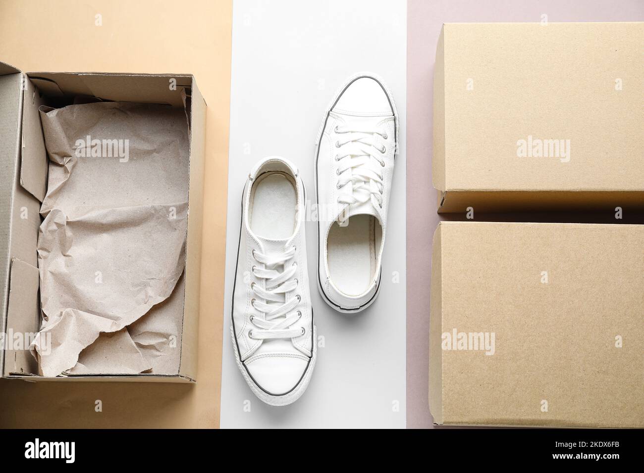 Cardboard boxes with white sneakers on light background Stock Photo - Alamy