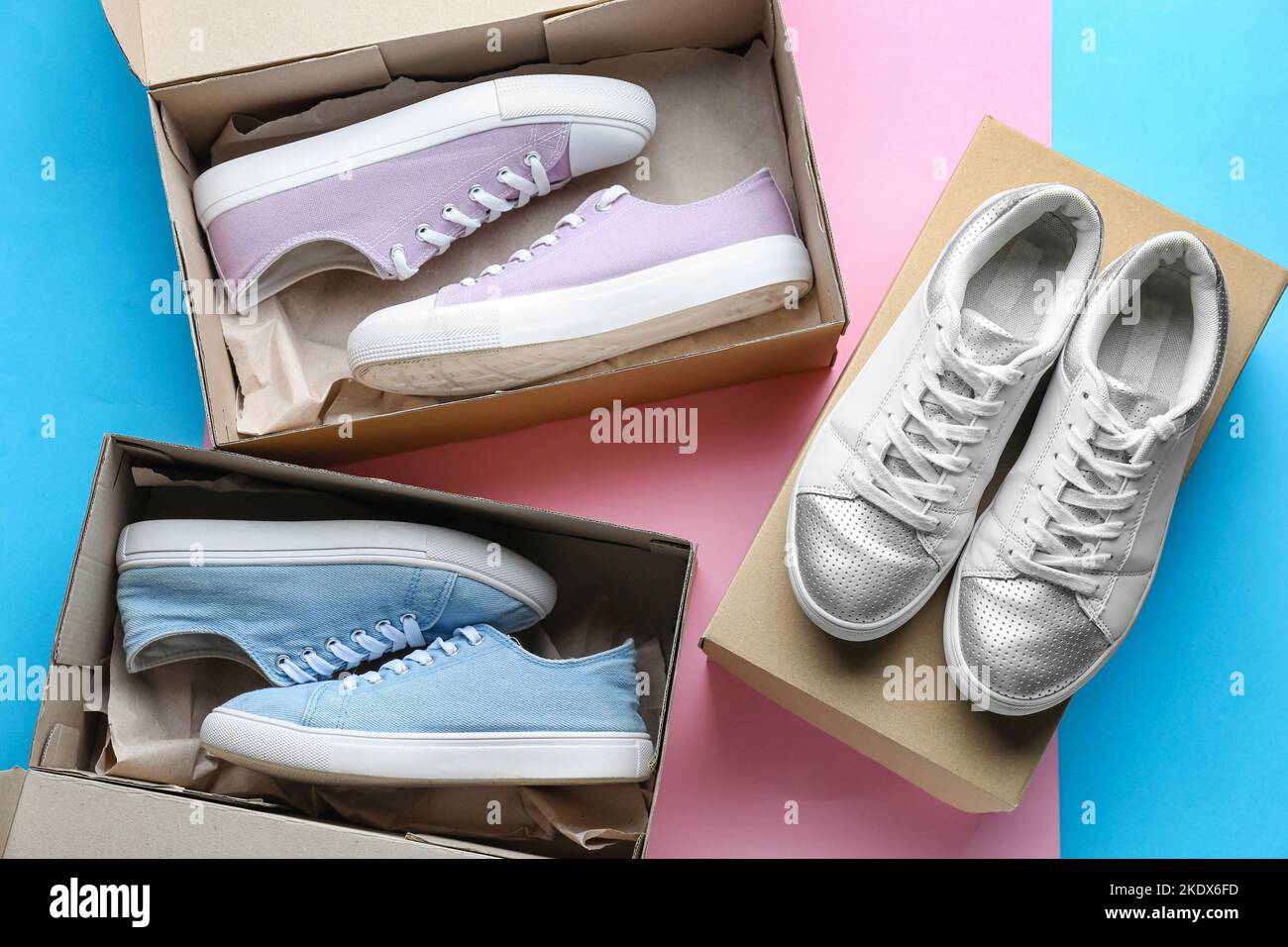 Cardboard boxes with sneakers on color background Stock Photo - Alamy