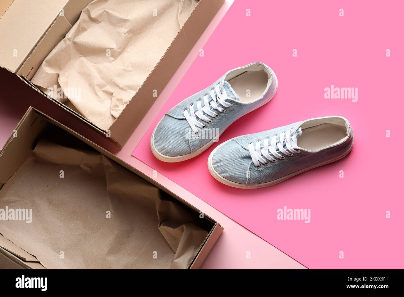 Cardboard box with blue sneakers on pink background Stock Photo - Alamy