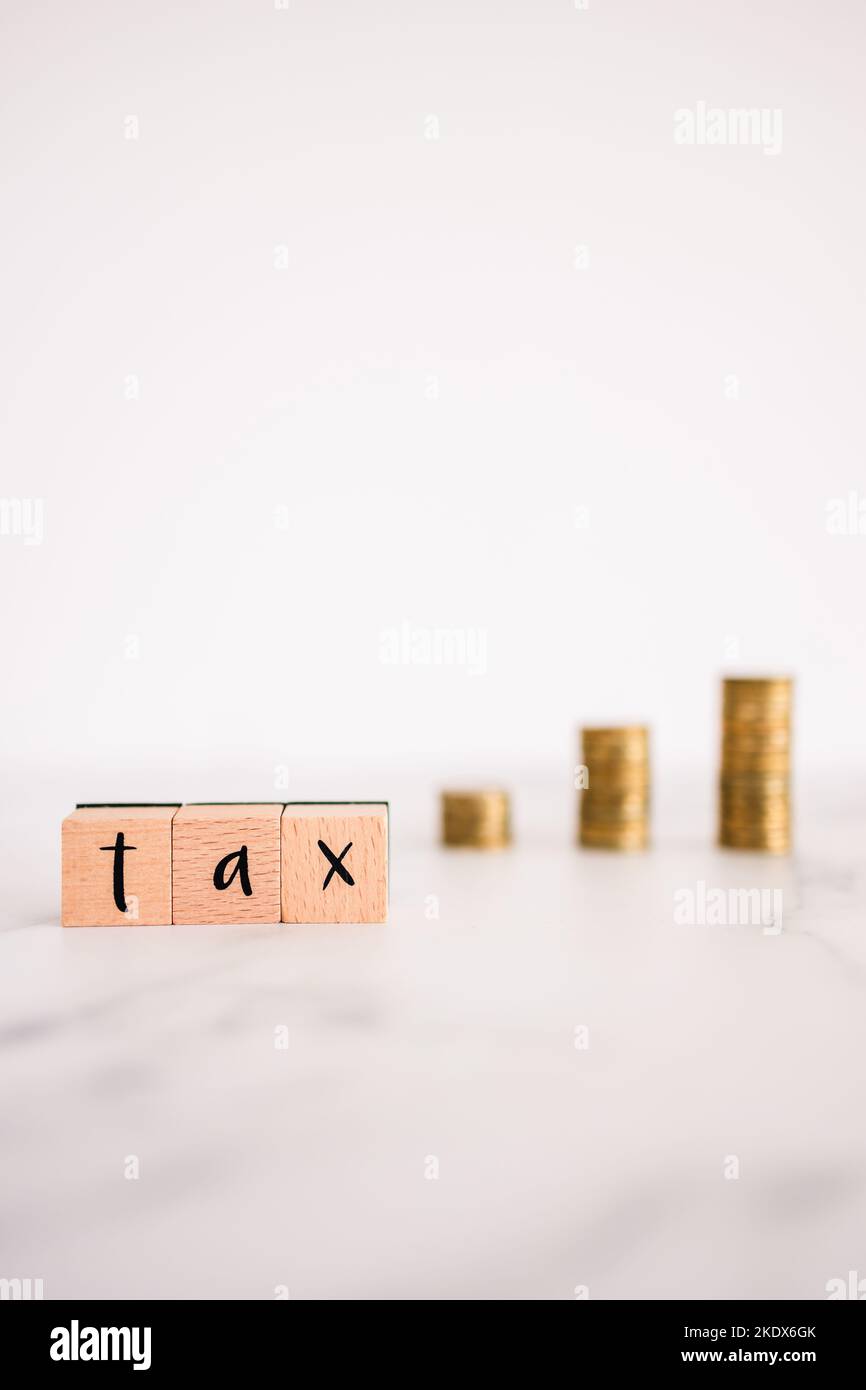 Tax text on top of growing stacks of coins, symbol of increasing tax ...