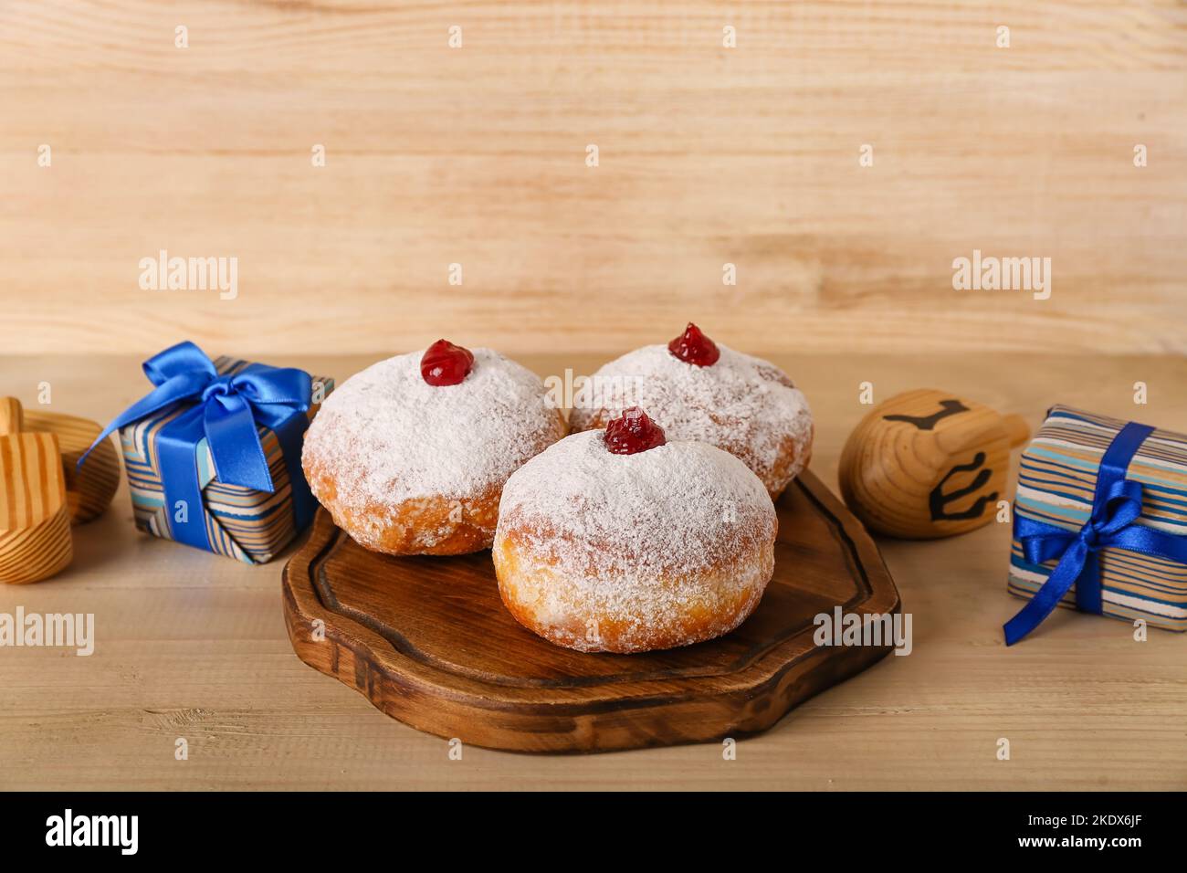 Board with tasty donuts, gifts and dreidels for Hannukah celebration on ...