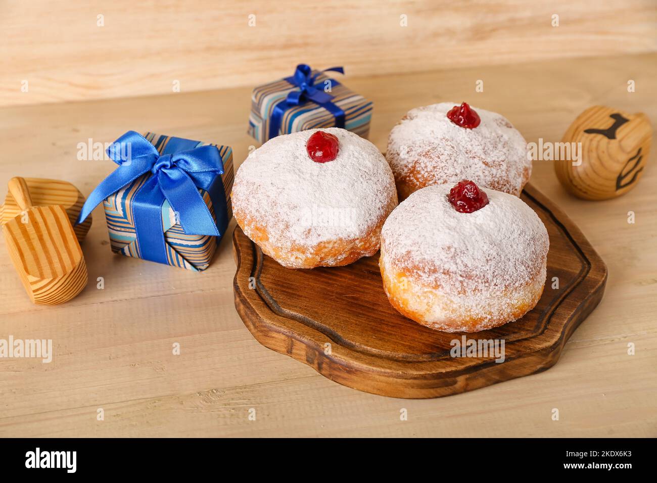 Board with tasty donuts, gifts and dreidels for Hannukah celebration on ...