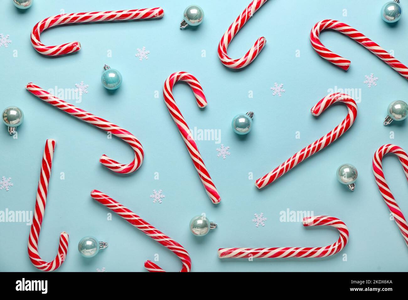 Candy canes with Christmas balls on blue background Stock Photo - Alamy