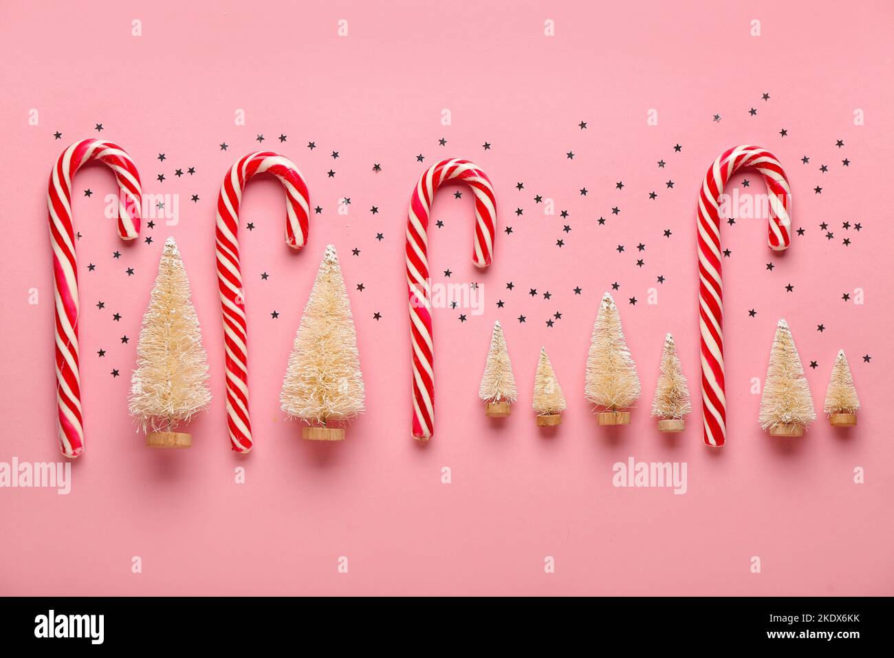 Candy canes with Christmas trees and stars on pink background Stock ...